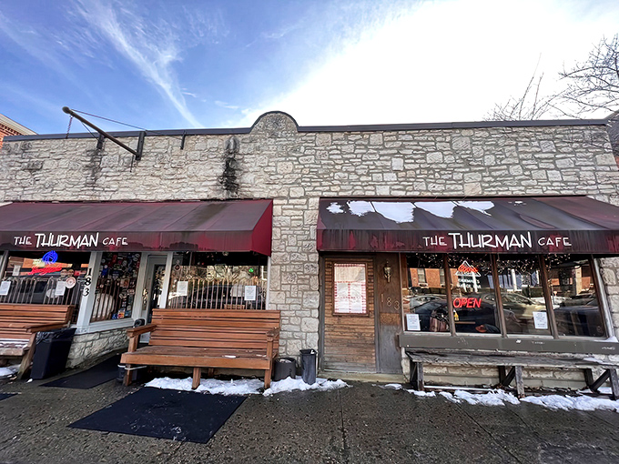 The unassuming stone exterior with its crimson awning doesn't scream "burger legend," but the wooden benches outside hint at something worth waiting for.