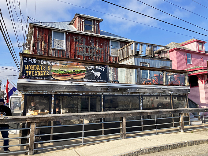 The weathered wooden exterior of The Goat stands proudly against Hampton's skyline, like a delicious pirate ship that decided to drop anchor and serve burgers instead.