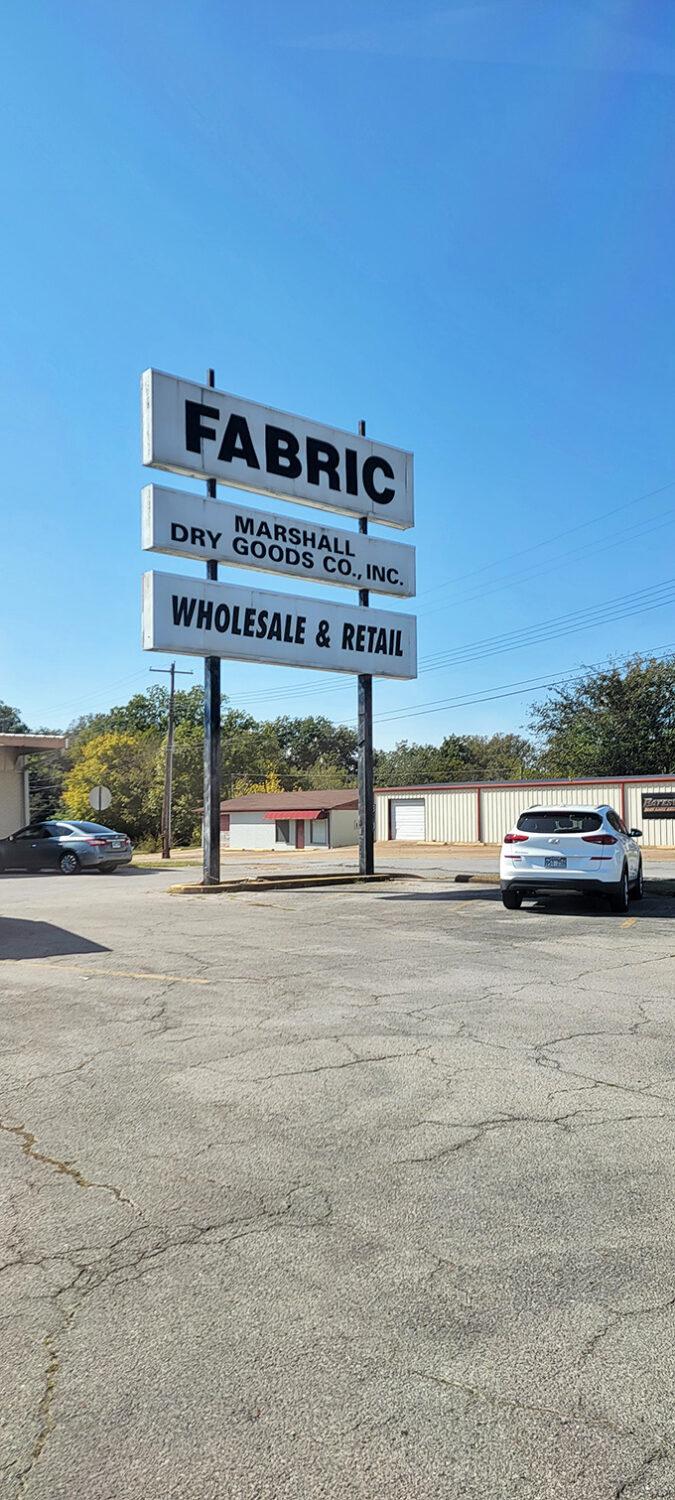 The sign says "FABRIC" with the subtlety of a Broadway marquee. No false advertising here&mdash;just a promise of textile treasures awaiting inside.