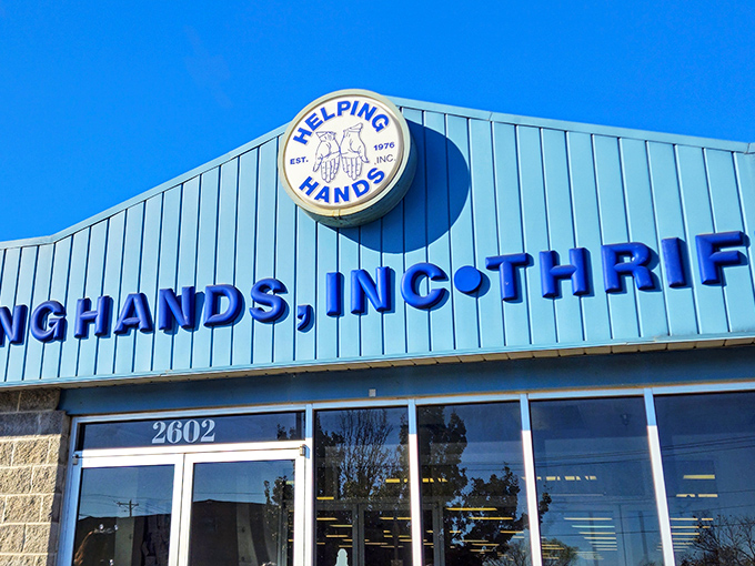 The bright blue facade of Helping Hands stands like a beacon of bargain-hunting hope against the Arkansas sky, promising treasures within.
