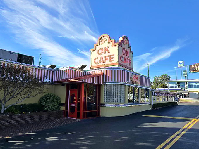 The iconic red and white striped awning of OK Cafe stands like a beacon of comfort food promise against the Atlanta sky.