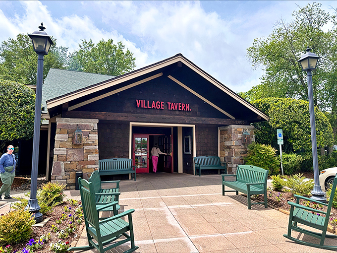 The rustic stone fa&ccedil;ade and welcoming teal benches at Village Tavern's entrance promise comfort before you even cross the threshold. 