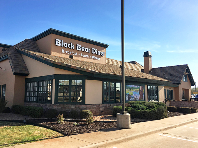 The mountain lodge meets Main Street America at Black Bear Diner's Quail Springs location. That blue bear silhouette promises comfort food salvation inside.