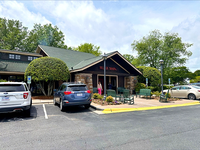 The rustic stone fa&ccedil;ade and welcoming teal benches at Village Tavern's entrance promise comfort before you even cross the threshold. 