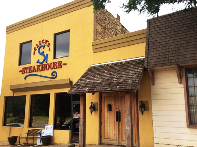 The bright yellow exterior of Click's Steakhouse stands like a beacon of carnivorous delight in Pawnee, promising beef-based bliss to those wise enough to make the journey.