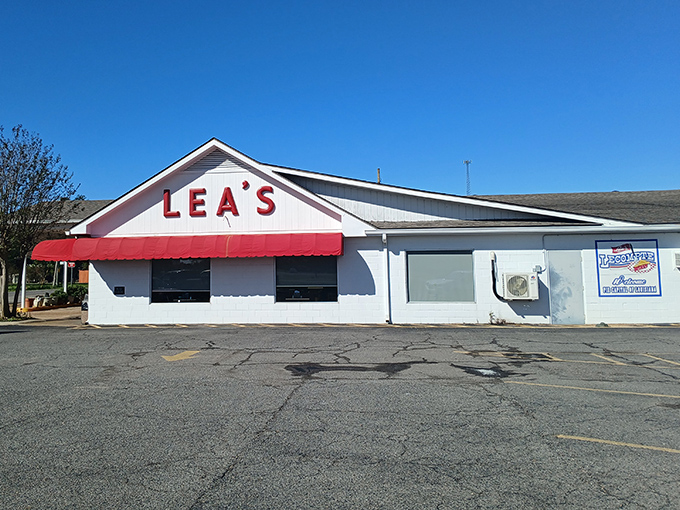 Lea's iconic white exterior with its cherry-red awning stands as a beacon of hope for hungry travelers. Simple, unassuming, and promising delicious rewards inside. 