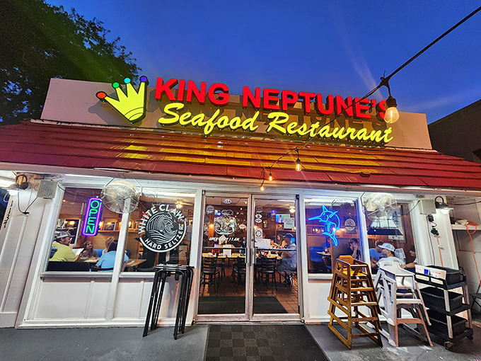 The unassuming exterior of King Neptune's hides culinary treasures within. Those red umbrellas aren't just for show—they're beacons for seafood lovers.