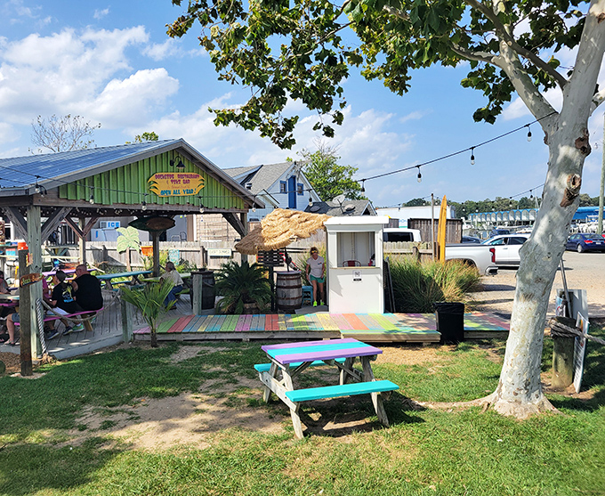 Rainbow-colored picnic tables create a beachside paradise where your toes can wiggle in the sand while your taste buds dance with delight.