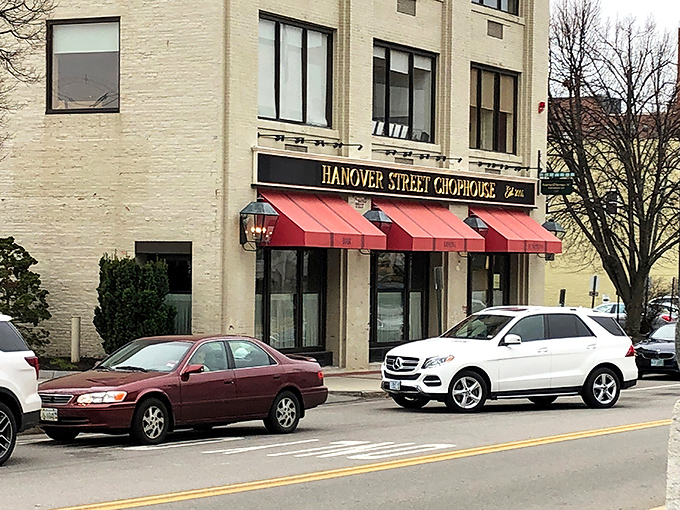 The iconic red awning beckons like a culinary lighthouse, promising refuge from ordinary dining experiences in downtown Manchester.