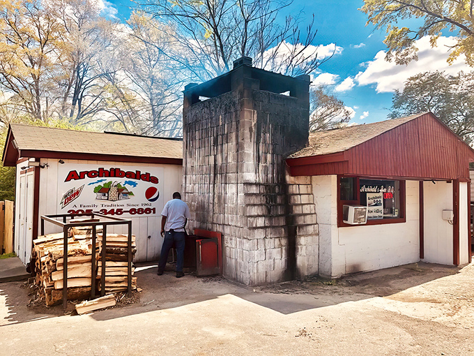 The humble cinderblock fortress that launched a thousand BBQ pilgrimages. Hickory wood stacked outside promises smoky delights within.