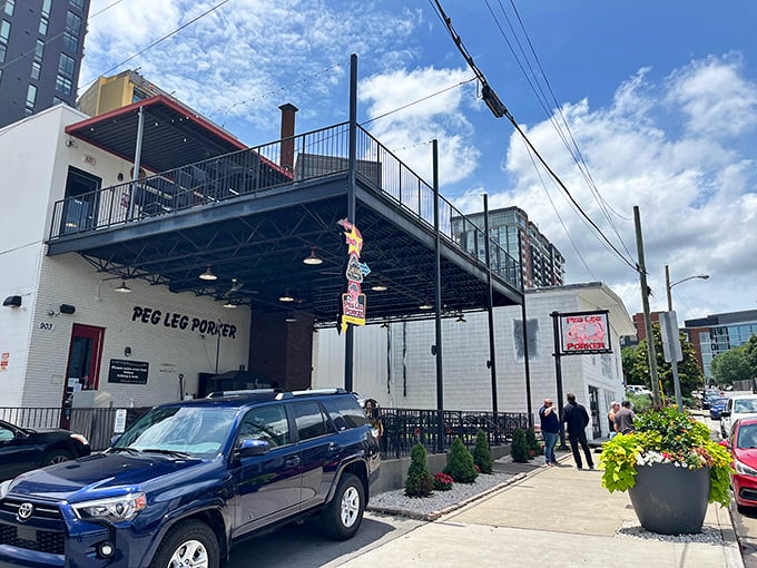 The glowing neon pig sign beckons hungry travelers like a barbecue lighthouse in Nashville's urban landscape.