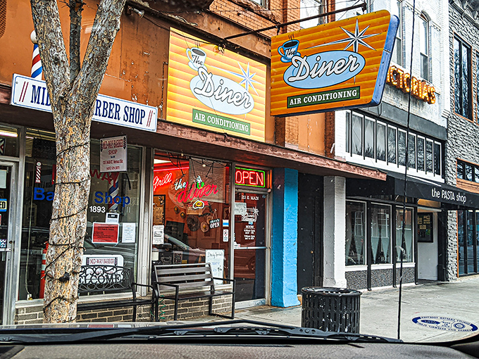 The Diner's vintage neon sign promises "AIR CONDITIONING" like it's 1955, a glowing beacon of breakfast hope on Norman's Main Street.