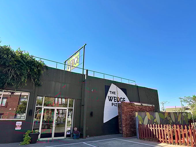 The Wedge's exterior is like a colorful storybook come to life. That vibrant orange fence and playful mural practically scream "good times and great pizza await inside!"