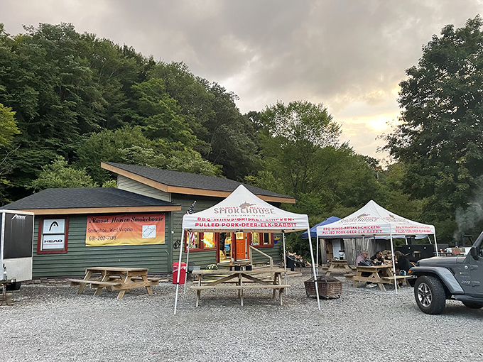 The green cabin nestled against West Virginia's lush forest backdrop isn't just a smokehouse&mdash;it's a portal to flavor country. Picnic tables await your food coma.