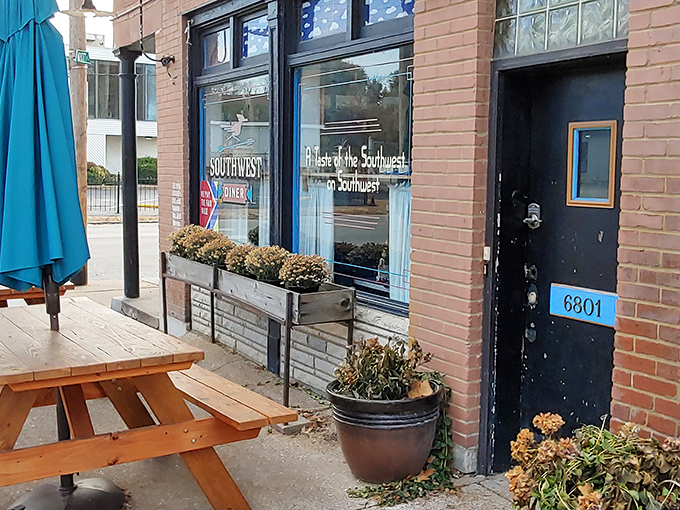 The unassuming brick exterior hides a southwestern flavor explosion within, where the patio's colorful chairs hint at the vibrancy waiting inside.