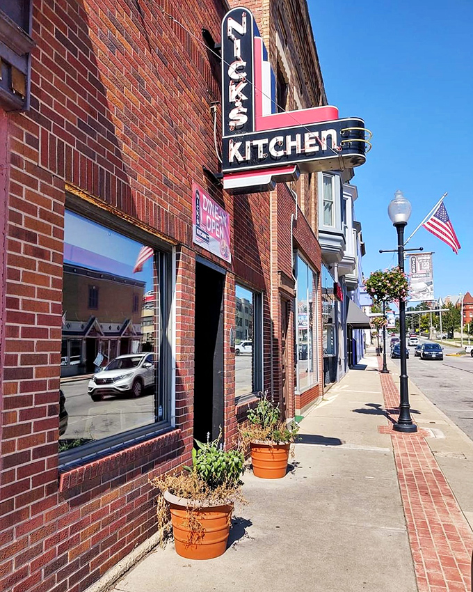 The iconic neon sign of Nick's Kitchen stands as a beacon of culinary history on Huntington's Jefferson Street. A century of tenderloin tradition lives behind this brick fa&ccedil;ade.