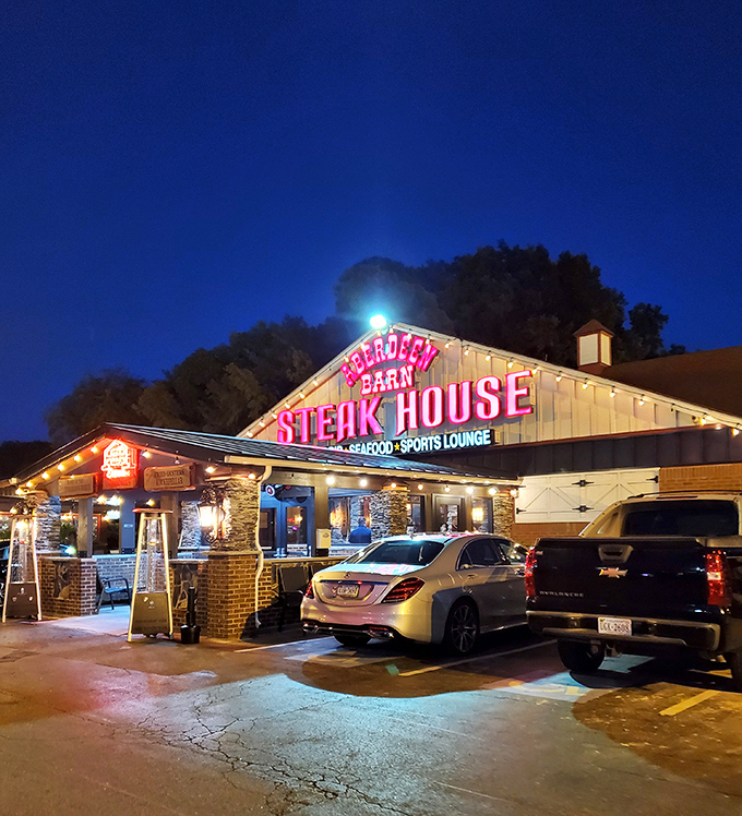 The iconic red neon sign of Aberdeen Barn glows against the twilight sky, a beacon for hungry travelers and locals alike seeking steakhouse perfection.