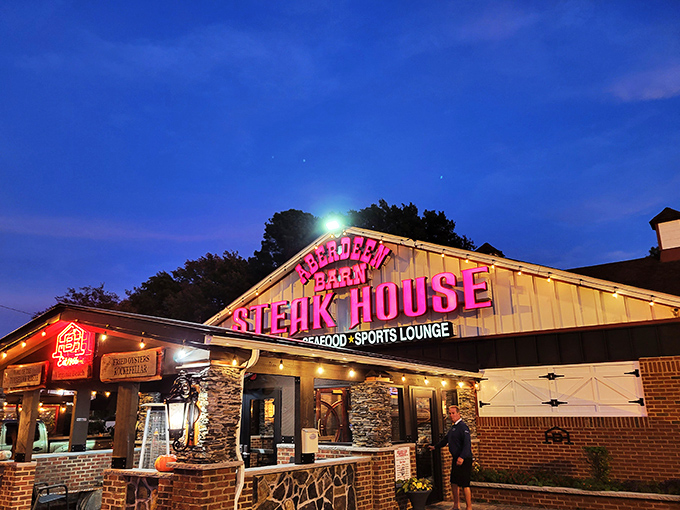The iconic red neon sign of Aberdeen Barn glows against the twilight sky, a beacon for hungry travelers and locals alike seeking steakhouse perfection.