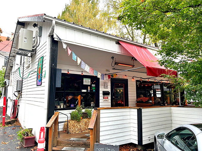 The charming white exterior of Goose Hollow Inn, where weeping willows create nature's perfect canopy for Portland's beloved sandwich sanctuary.