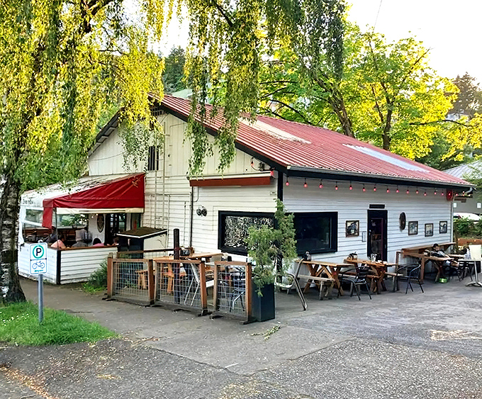 The charming white exterior of Goose Hollow Inn, where weeping willows create nature's perfect canopy for Portland's beloved sandwich sanctuary.