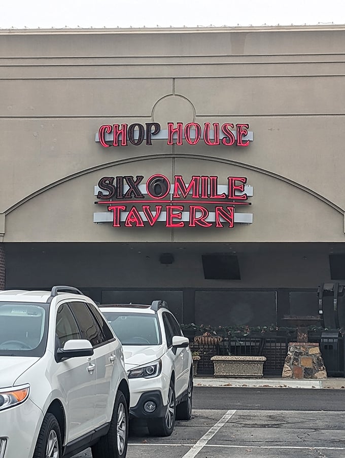 The red neon sign of Six Mile Chop House beckons like a carnivore's lighthouse, promising safe harbor for the steak-obsessed traveler in Lawrence.