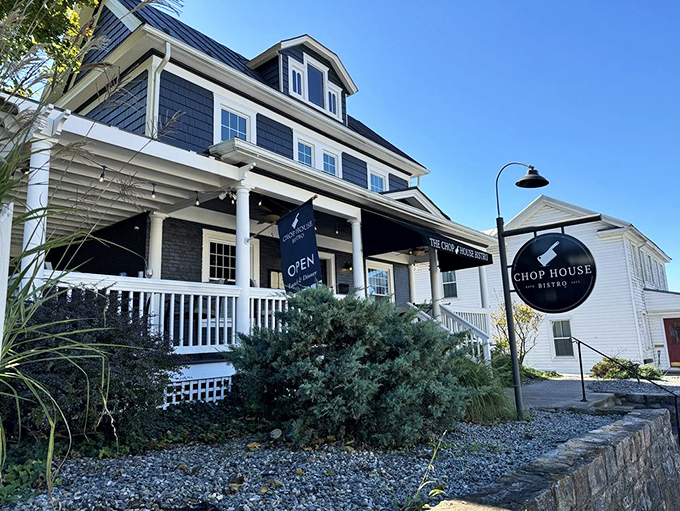 The navy blue colonial exterior of Chop House Bistro stands like a culinary lighthouse in Luray, beckoning hungry travelers with its classic charm and welcoming porch.