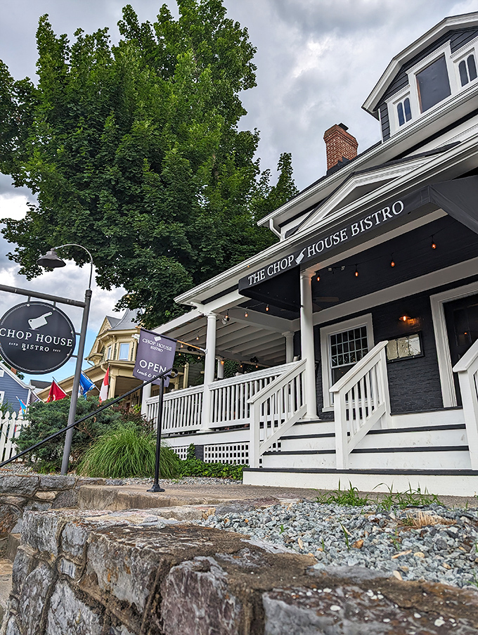The navy blue colonial exterior of Chop House Bistro stands like a culinary lighthouse in Luray, beckoning hungry travelers with its classic charm and welcoming porch.