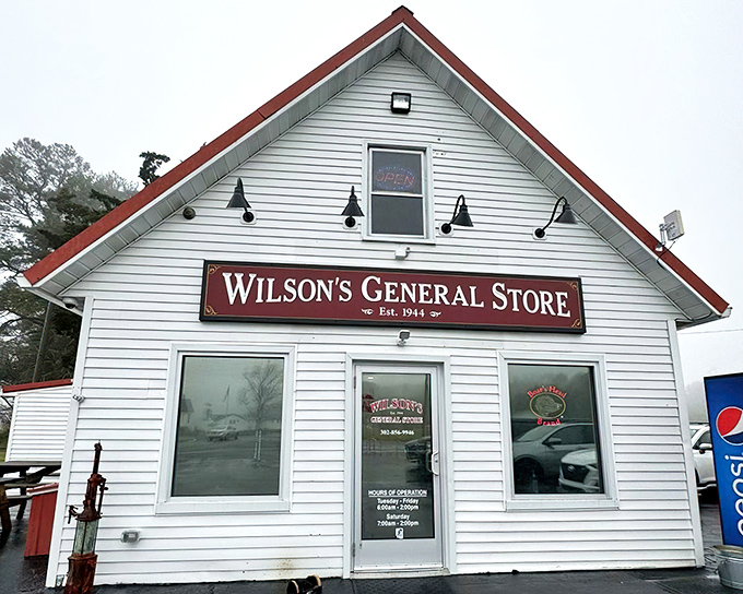 The classic white clapboard exterior of Wilson's General Store stands proudly against a blue Delaware sky, promising culinary treasures within those humble walls.