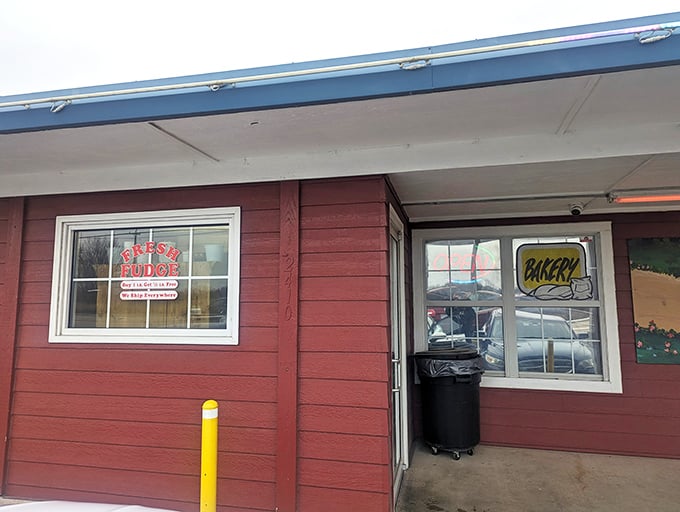 The welcoming front porch of Amish Country Store beckons with its classic red siding, white railings, and that charming "Amish Buggy Xing" sign that promises authentic flavors await inside. 