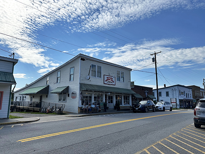 The classic white clapboard exterior of Floyd Country Store stands as a beacon of Appalachian charm, complete with that iconic green-striped awning that practically whispers, "Come on in, y'all."