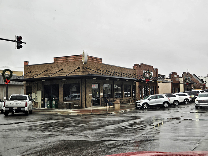 The humble brick exterior of Busy Bee Caf&eacute; stands like a beacon of breakfast hope, its cheerful yellow sign promising delicious revelations within.
