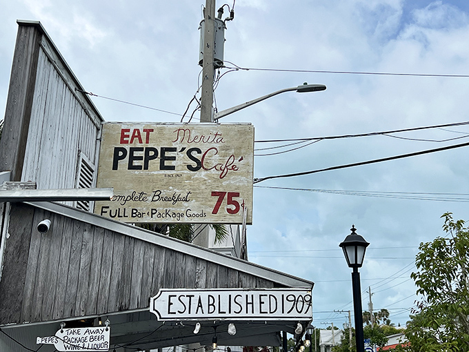The weathered white clapboard exterior of Pepe's Cafe stands as a time capsule of Old Key West charm, beckoning hungry travelers with promises of island-time breakfast delights.