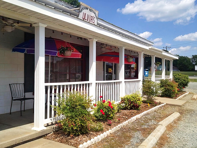 Ulvia's charming white exterior with vibrant red awnings feels like a warm embrace, proving that sometimes the most memorable meals come from the most unassuming places.
