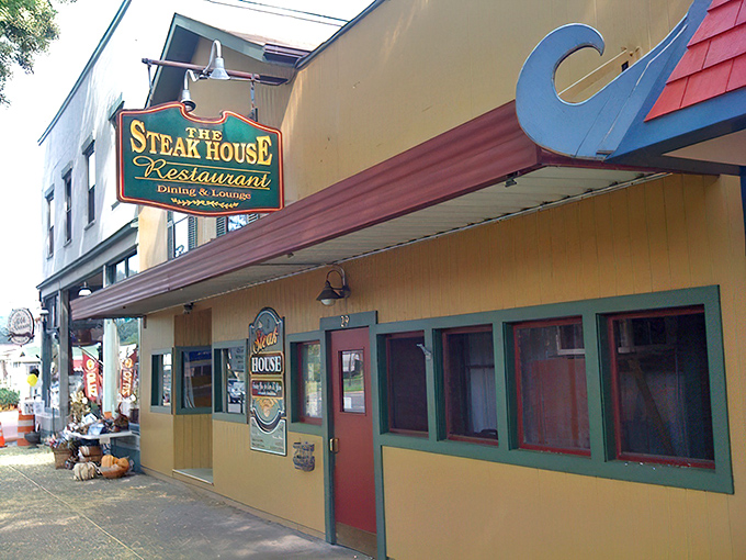 The charming yellow exterior of The Steak House stands proudly on Wellsboro's tree-lined main street, a beacon for hungry travelers seeking carnivorous bliss.