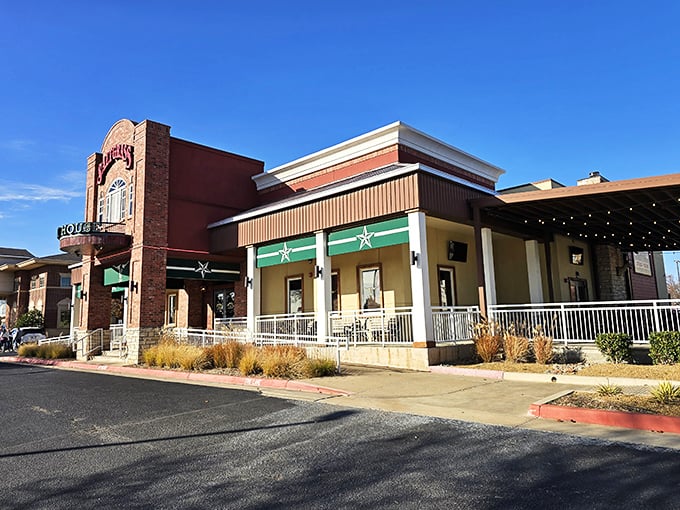 The brick facade of Saltgrass stands like a carnivore's lighthouse, beckoning hungry travelers with its iconic red and green signage against the Oklahoma sky.