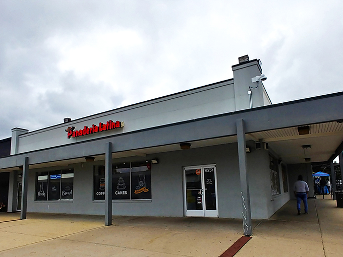 The bright red signage of Panaderia Latina beckons like a beacon of culinary promise. Coffee, cakes, and pastries await behind those unassuming doors.