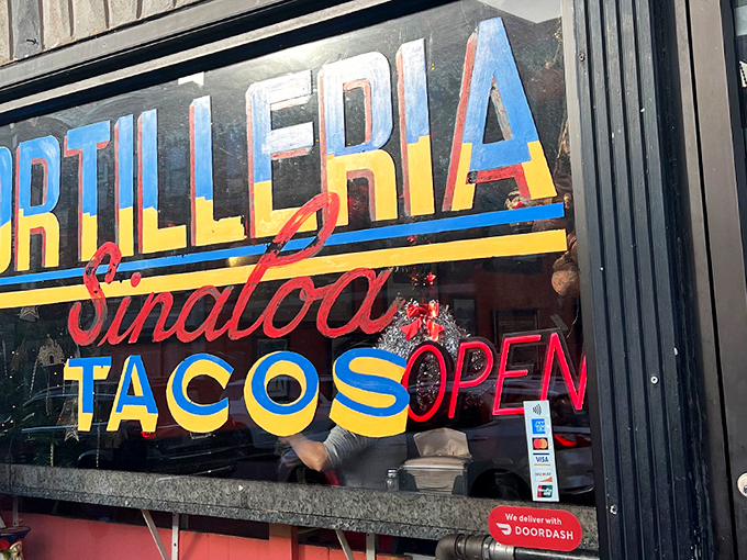The storefront announces itself with vibrant blue, red, and yellow lettering that seems to say, "Yes, this is the real deal." Colorful ceramic pitchers in the window hint at the authenticity waiting inside.