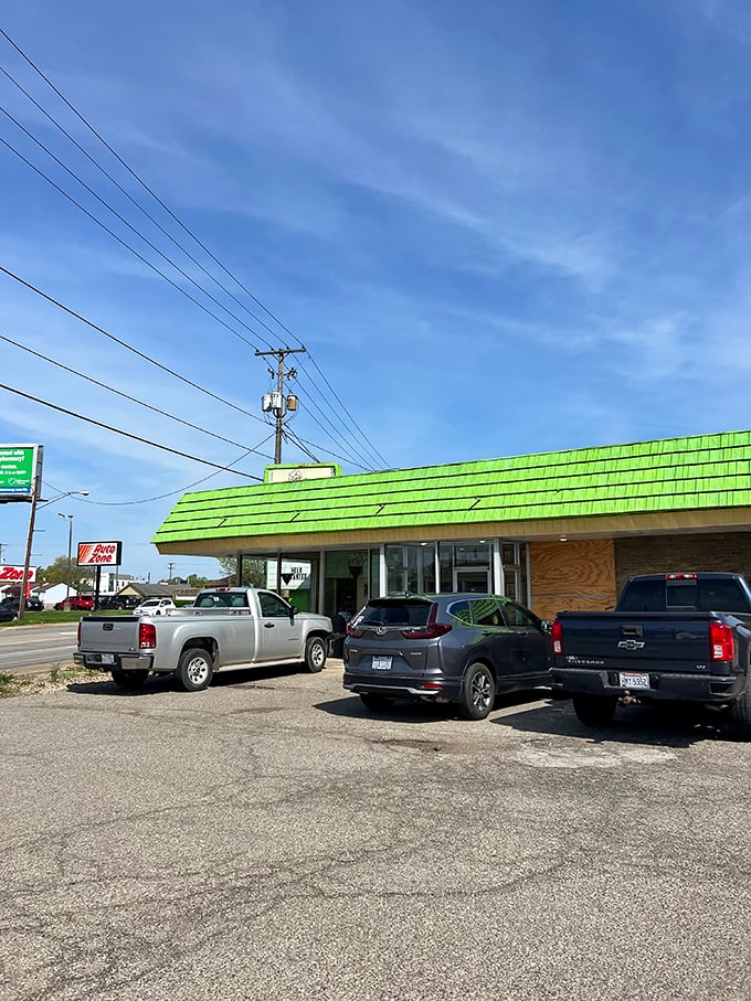 The mint-green shingled roof beckons like a sugar-coated lighthouse, guiding hungry travelers to this unassuming temple of fried dough excellence.