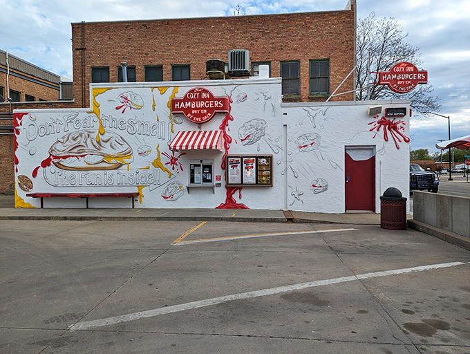 The humble white facade of Cozy Inn, where culinary magic has happened since the Roaring Twenties. "Don't fear the smell, the fun is inside!"