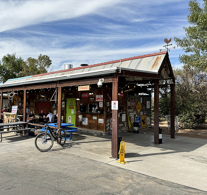The rustic roadside charm of Jalape&ntilde;o Buck's beckons hungry travelers with its weathered metal roof and promise of smoky delights ahead.