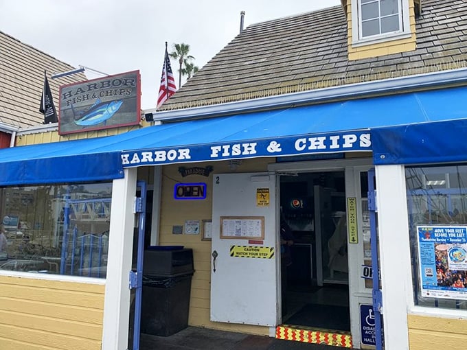 The bright blue awning of Harbor Fish & Chips stands as a beacon for seafood lovers, promising simple pleasures done right in Oceanside Harbor.