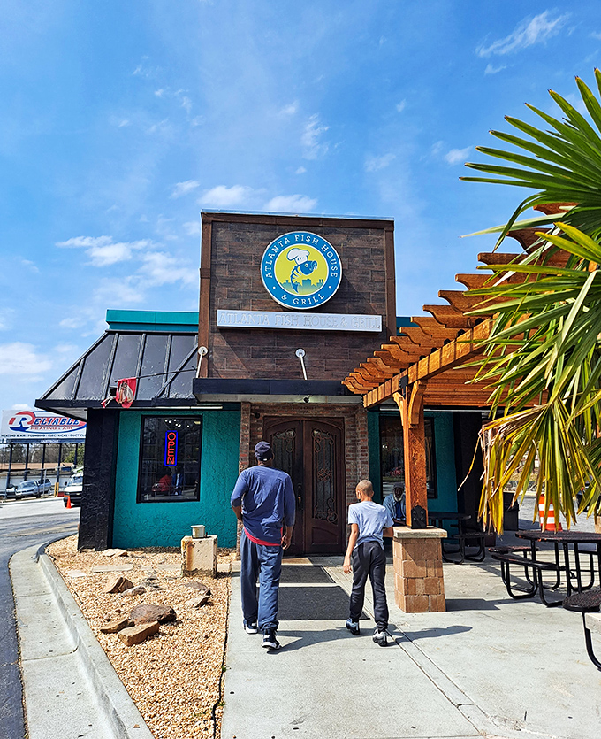 The teal and stone exterior beckons like a seafood lighthouse in Atlanta's urban landscape. That wooden pergola practically whispers "come sit awhile."