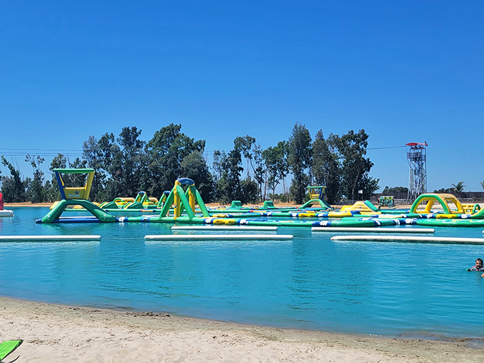 The aquatic playground stretches across crystal-clear water like a neon-colored mirage, promising adventures that'll make your inner child high-five your outer adult.