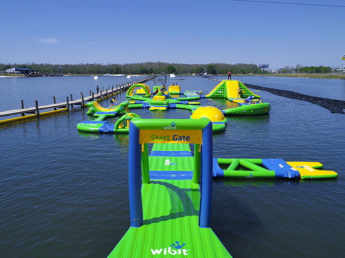 The neon green floating playground beckons like an aquatic Wonderland. Who needs expensive theme parks when paradise is floating right here?