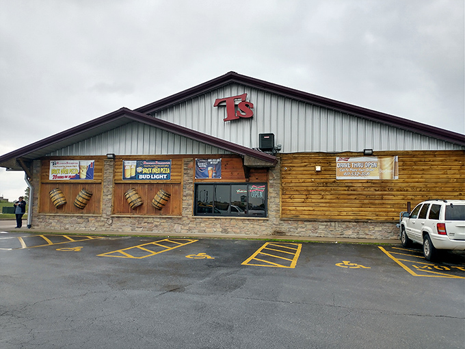 The log cabin exterior of T's Redneck Steakhouse glows with warm invitation as dusk settles, promising carnivorous delights within those rustic walls.
