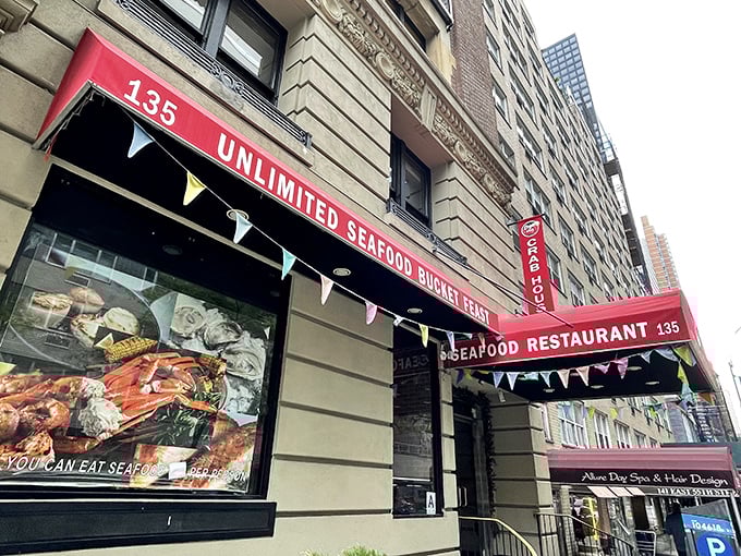 The bright red awning reading "UNLIMITED SEAFOOD BUCKET FEAST" works like a siren call to seafood lovers passing by on Manhattan's streets.