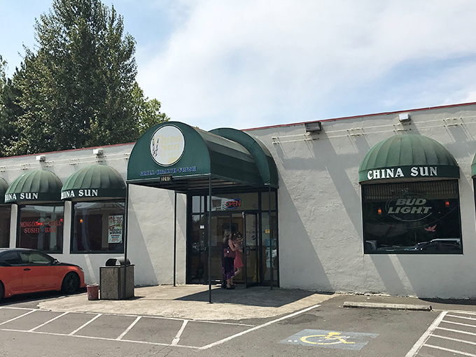 The distinctive green awnings of China Sun Buffet stand out against the white exterior, like beacons guiding hungry travelers to their destination.