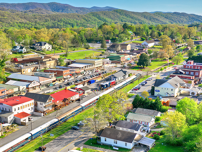 Blue Ridge unfolds like a storybook mountain town from above, its charming streets nestled among endless rolling green hills that seem to stretch into forever.