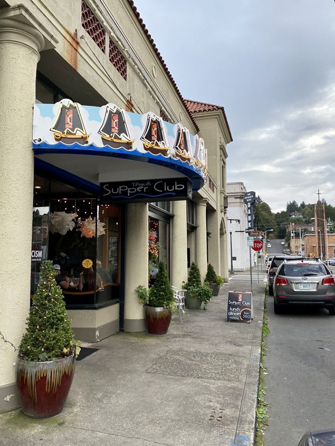 The blue awning with sailing ships beckons like a lighthouse for hungry souls. Astoria's historic charm meets culinary adventure at T. Paul's entrance.