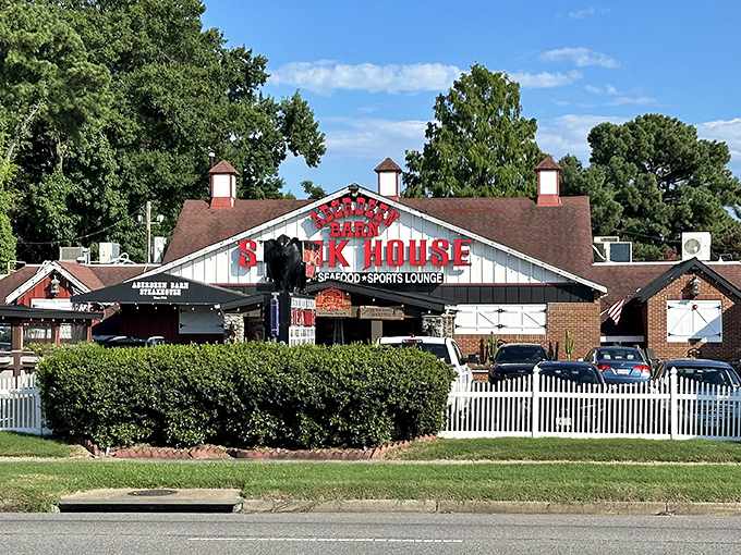 The iconic red neon sign of Aberdeen Barn glows against the twilight sky, a beacon for hungry travelers and locals alike seeking steakhouse perfection.